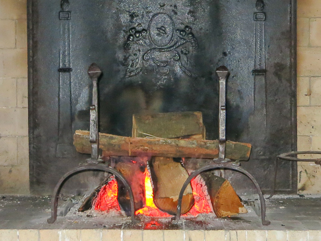 What is the purpose of andirons, firedogs and fireplace grates?